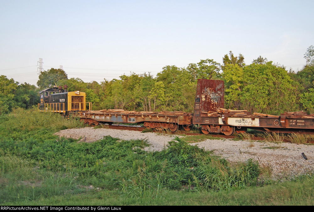 WAMX 929 pulls a string of empty flats that include three ex DODX 6-axle flatcars